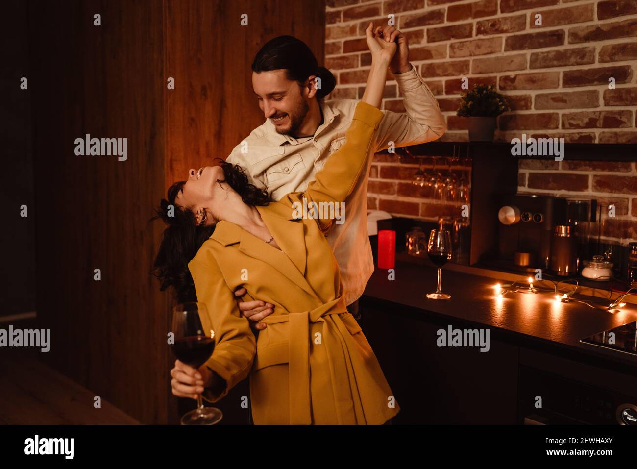 White romantic couple dancing while drinking wine at home indoors Stock ...