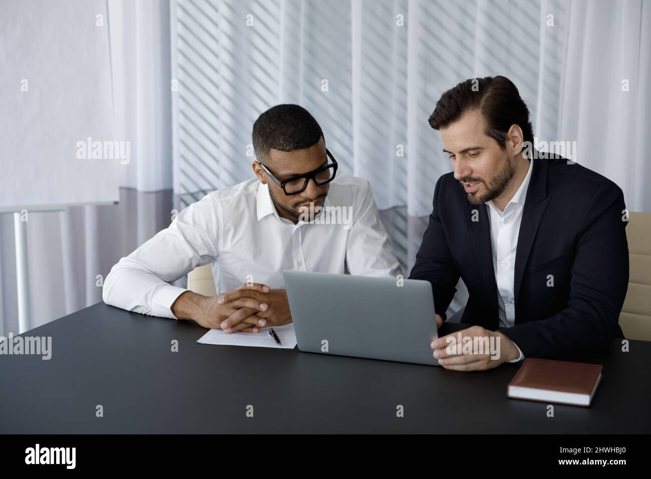 Concentrated two diverse business partners working on computer Stock ...