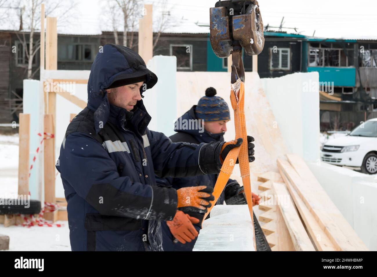 Installers adjust and install another ice block to the overall ...