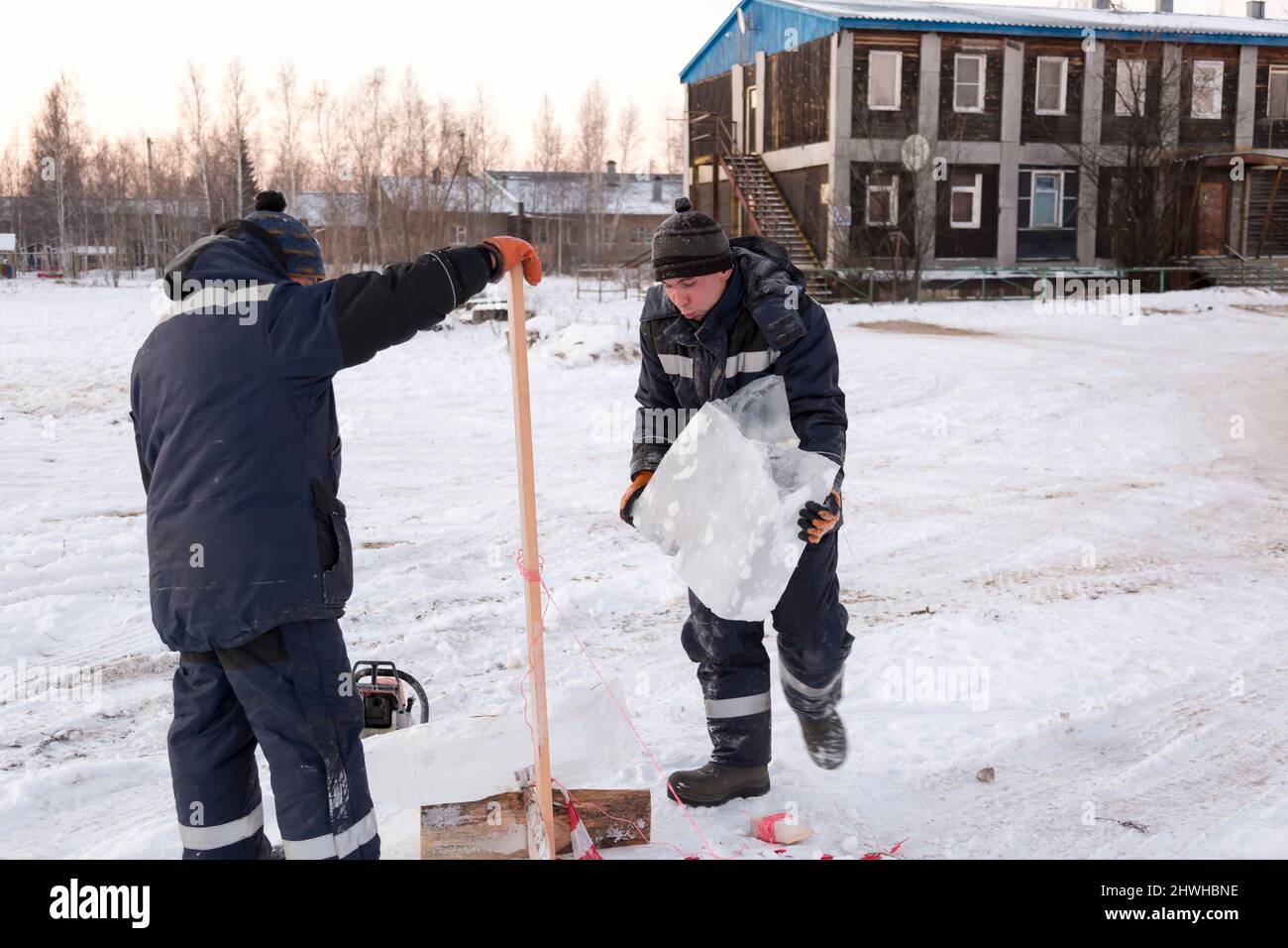 A worker drags an ice block with his hands along the assembly site of ...