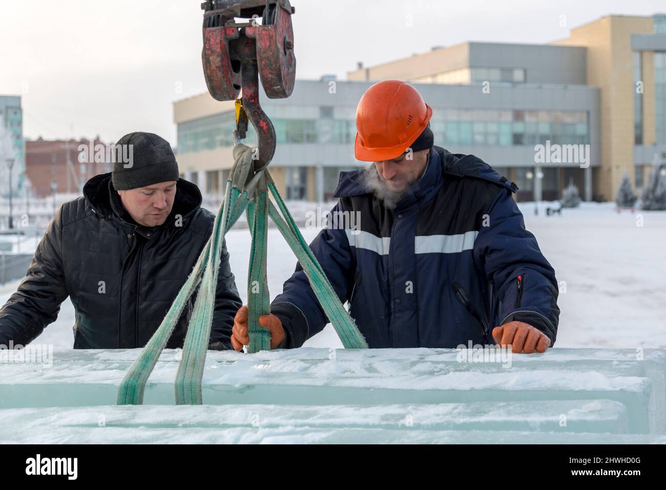 Slingers unload ice slabs with a truck crane Stock Photo - Alamy