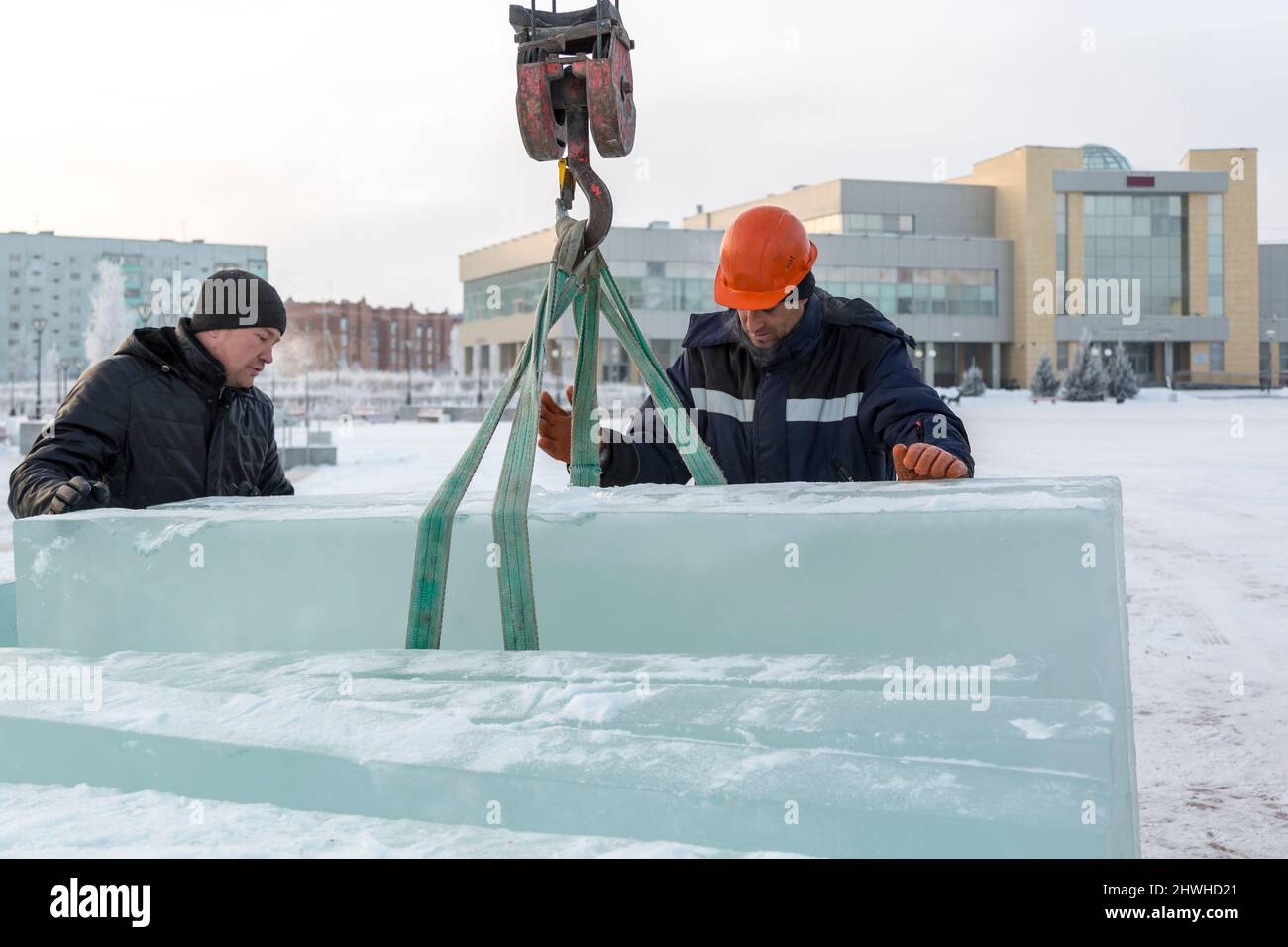 Slingers unload ice slabs with a truck crane Stock Photo - Alamy