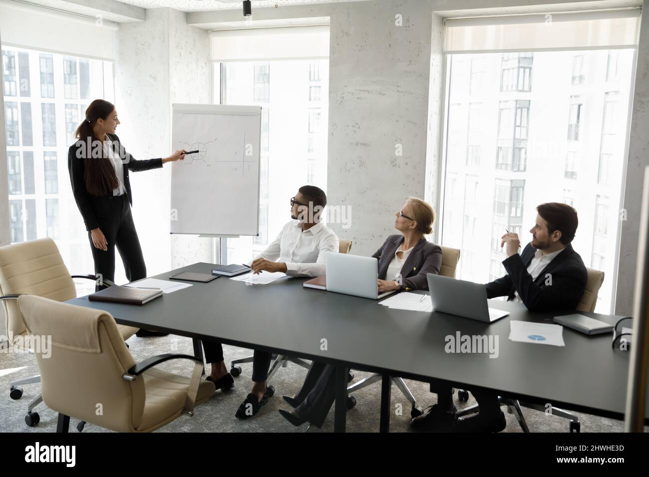 Young female speaker giving educational lecture to business people ...