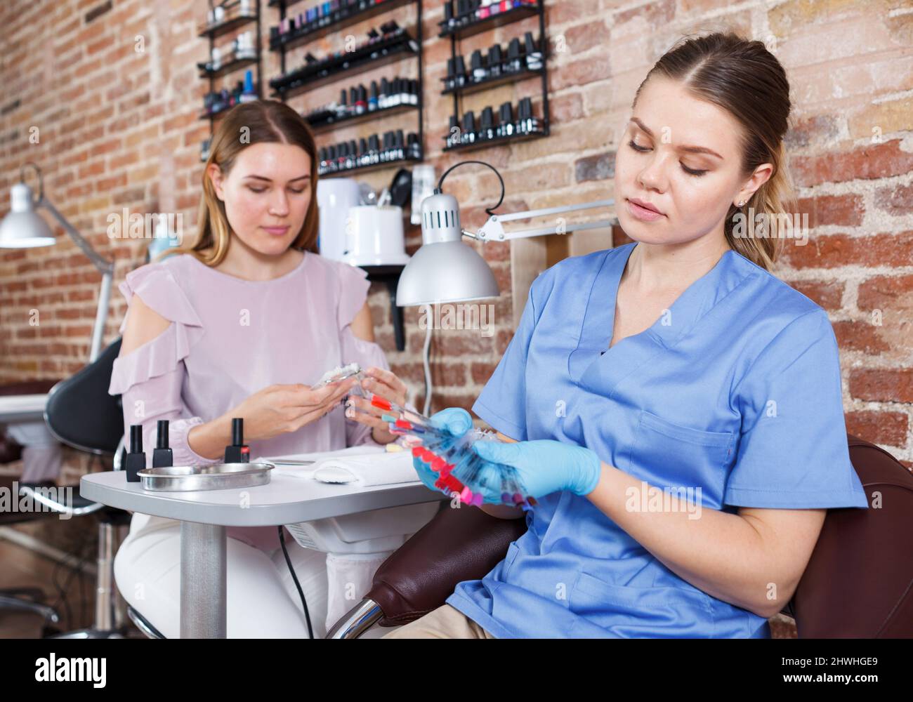Manicurist showing color samples of nail polish in nail salon Stock ...