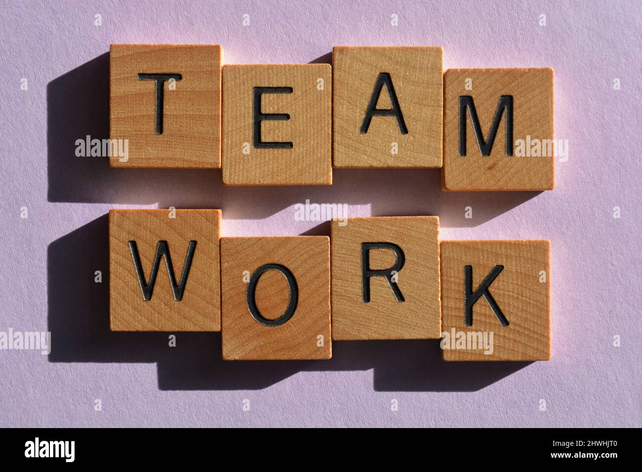 Team, Work, words in woode alphabet letters isolated on plain purple ...