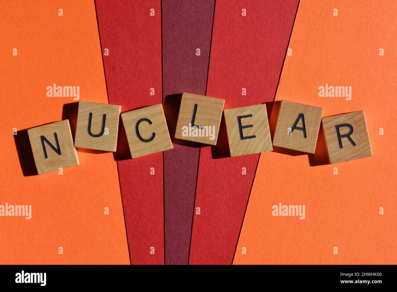Nuclear, word in wooden alphabet letters isolated on red and orange ...