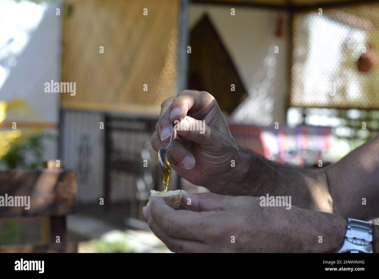 Honey dripping on a bread from a steel spoon Stock Photo - Alamy