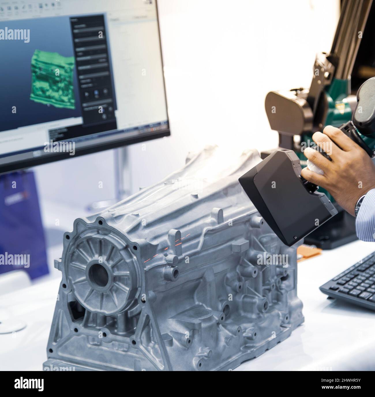 Industrial technician operating high technology handheld 3D CMM laser scanner inspecting engine ...