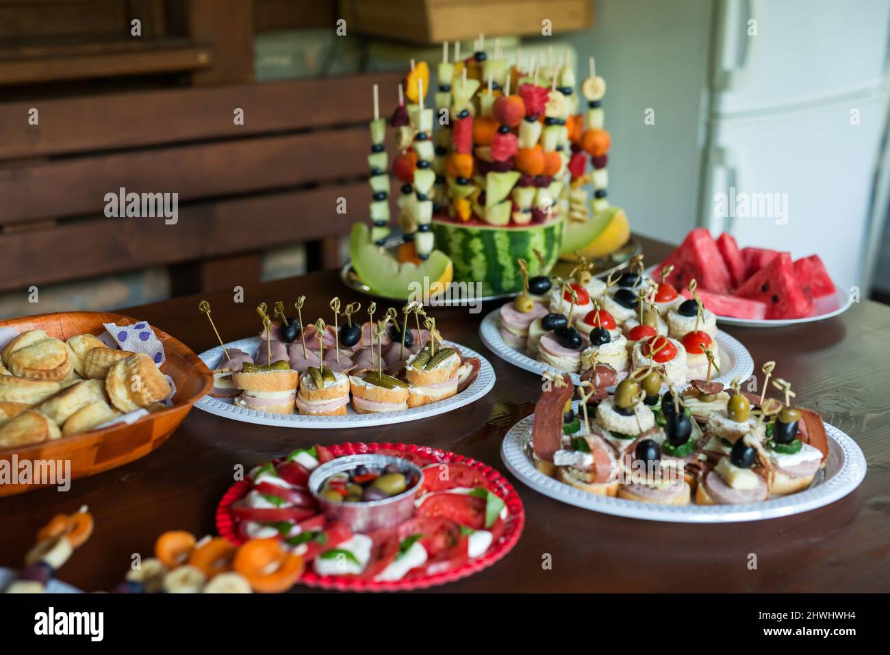 The buffet at the reception. Assortment of canapes on wooden board ...