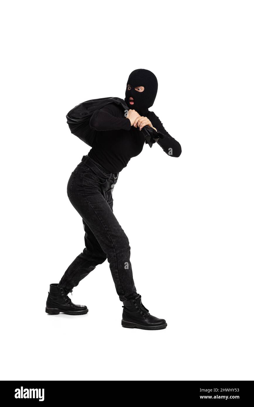 Portrait of young anonymous person wearing black outfit and balaclava ...