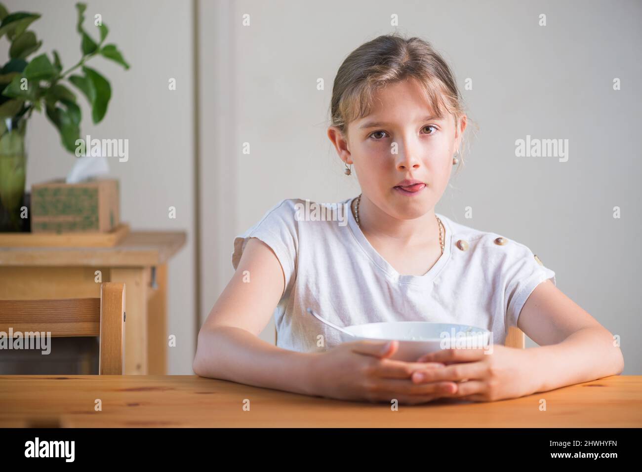 Blonde teenage girl eating cereal for breakfast. Lifestyle portrait ...