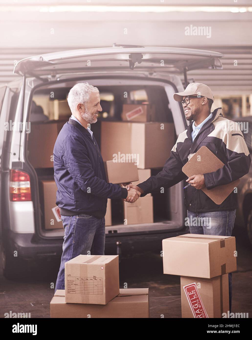 Delivered by the best in the business. Shot of two delivery men shaking ...