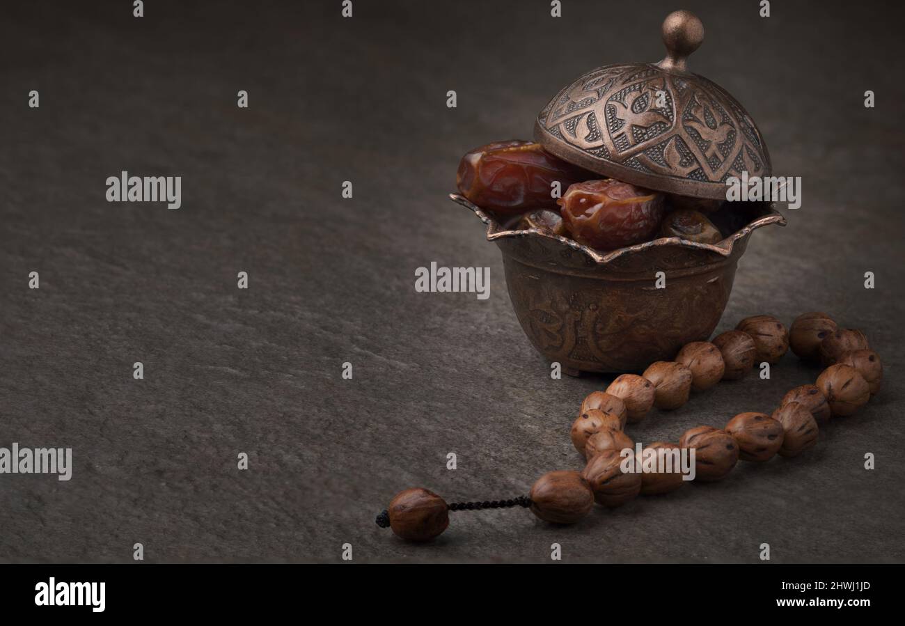 Dates and rosary beads at stone surface Stock Photo - Alamy