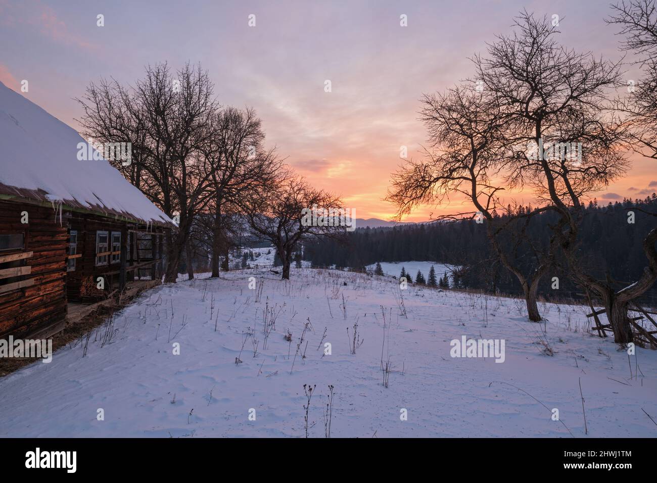 Small alpine village and winter snowy mountains in first sunrise ...