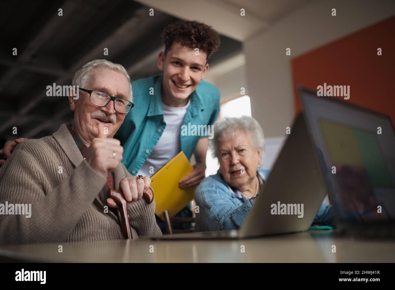 Senior group in retirement home with young instructor learning together ...