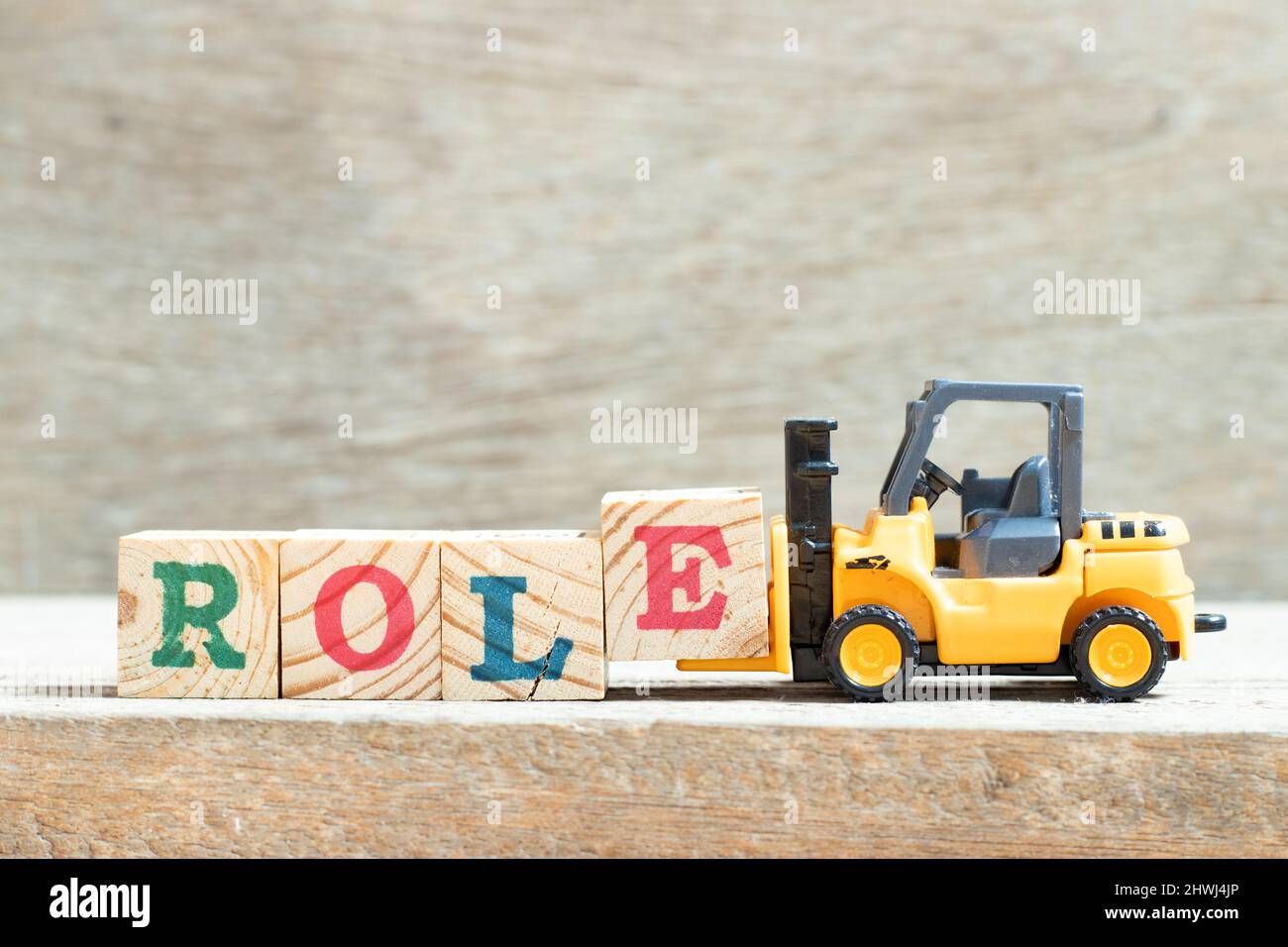 Toy forklift hold letter block e to complete word role on wood ...