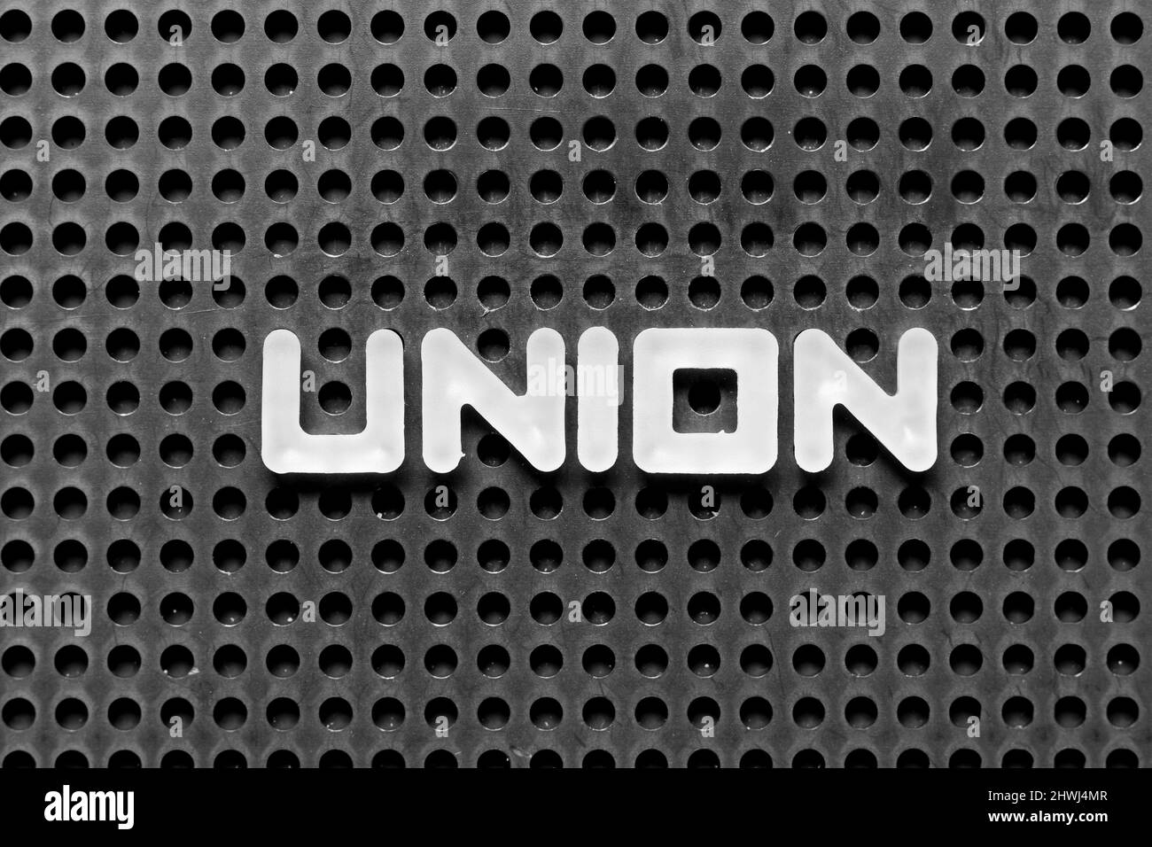 White alphabet letter in word union on black pegboard background Stock ...