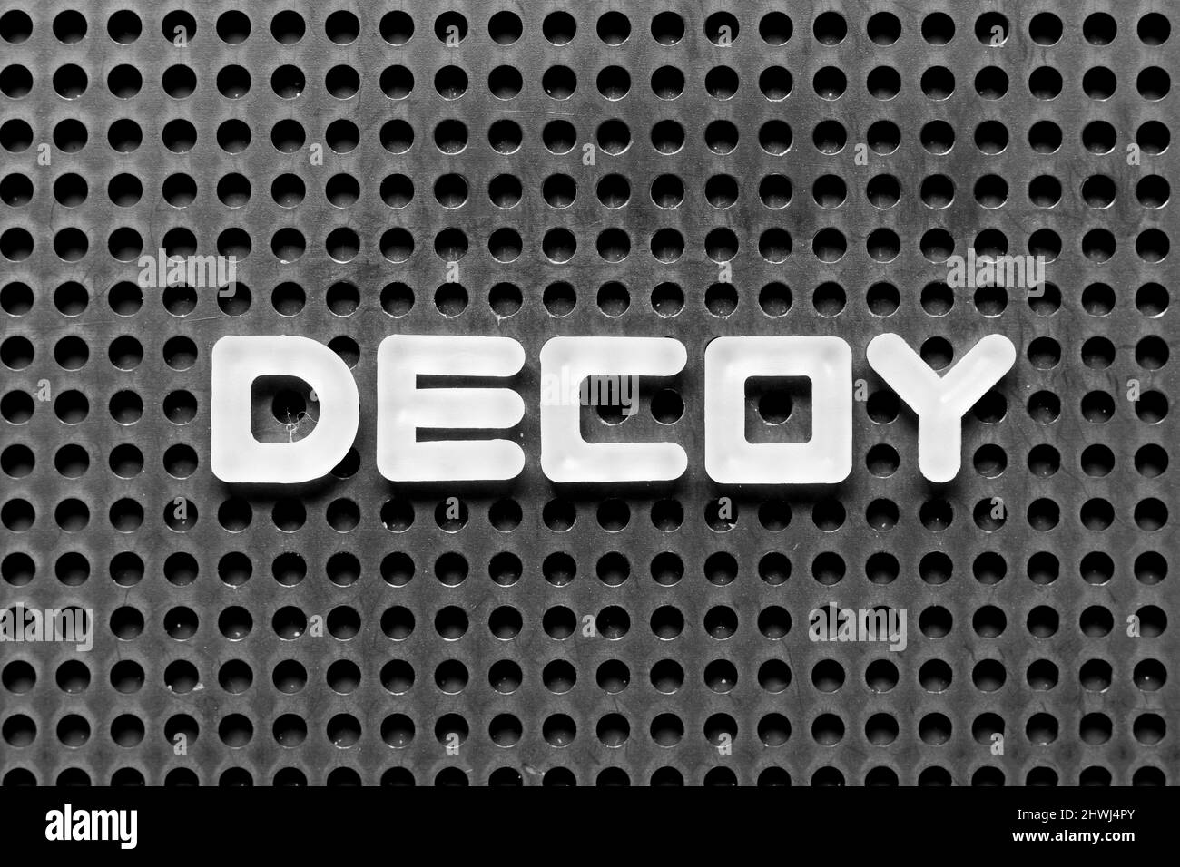 White alphabet letter in word decoy on black pegboard background Stock ...