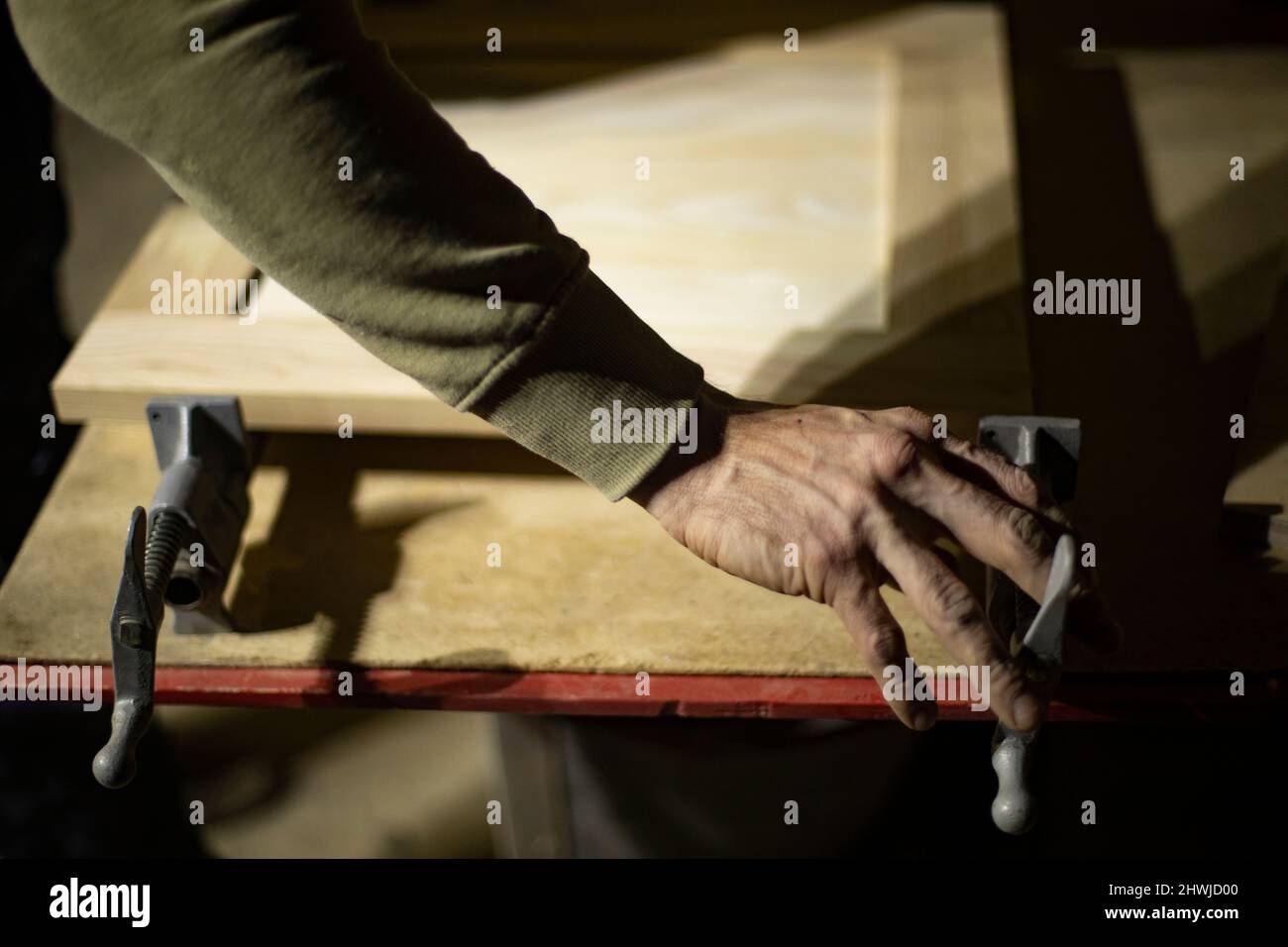 Work with wood. Fixing board. Carpenter installs part. Wood processing ...