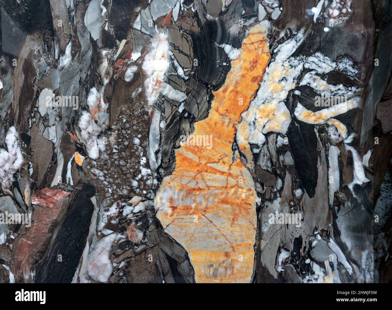 Texture of natural gray-black quartz stone with orange mineral ...