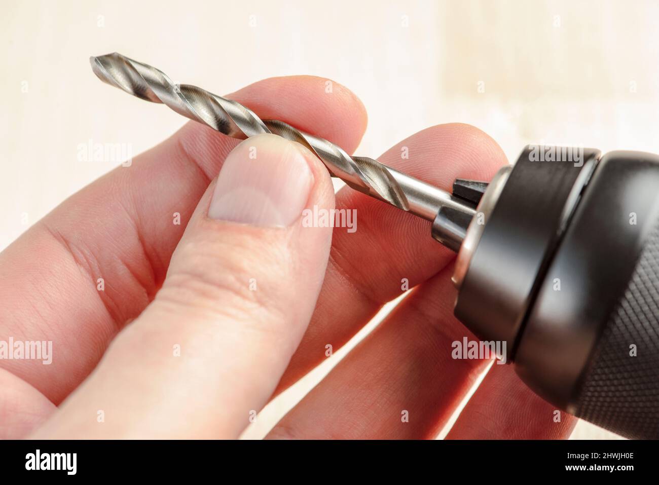 Installing a drill bit in a drill, hands take a drill and install it in ...