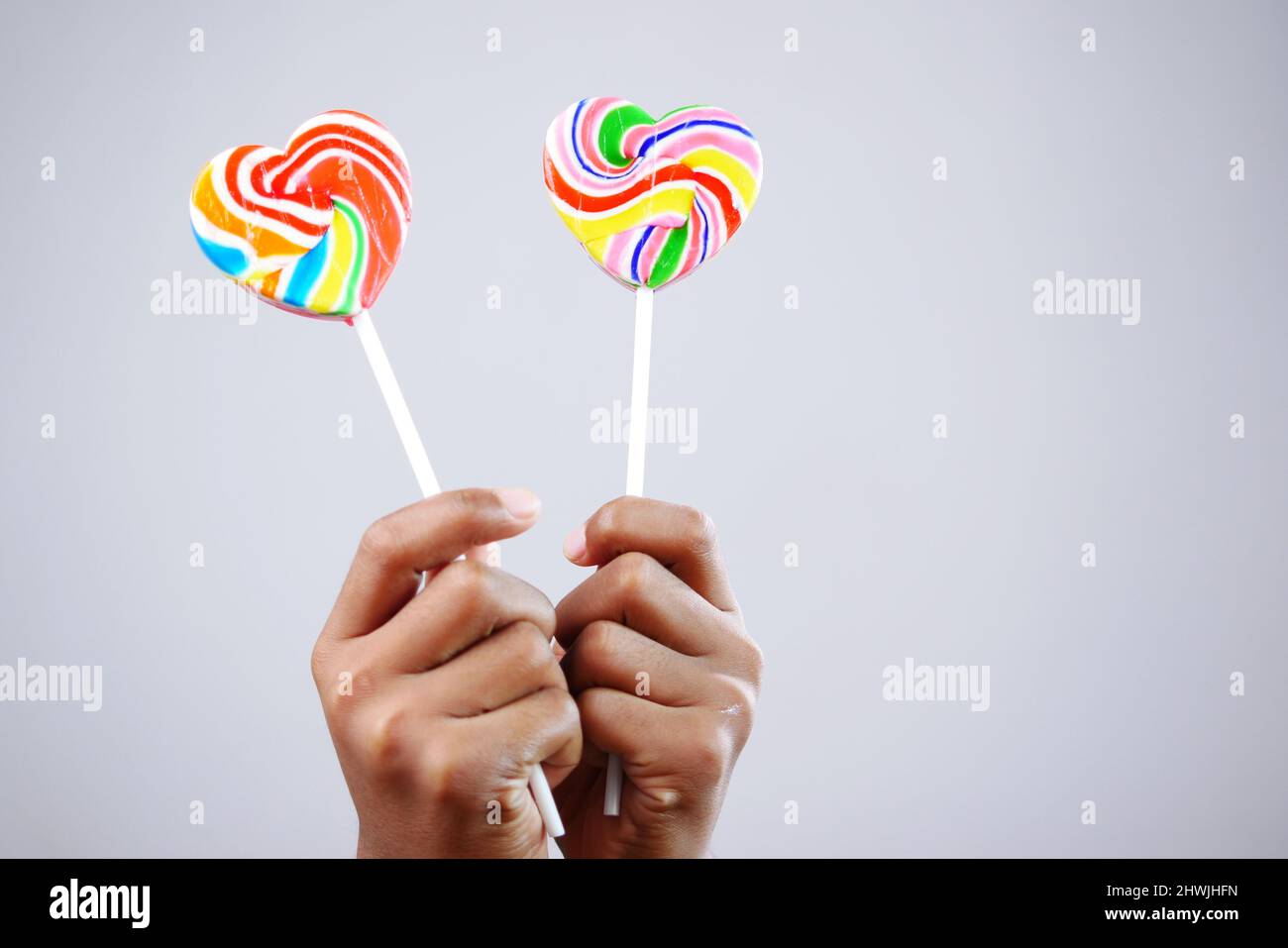 hand holding lollipop candy on white background Stock Photo - Alamy