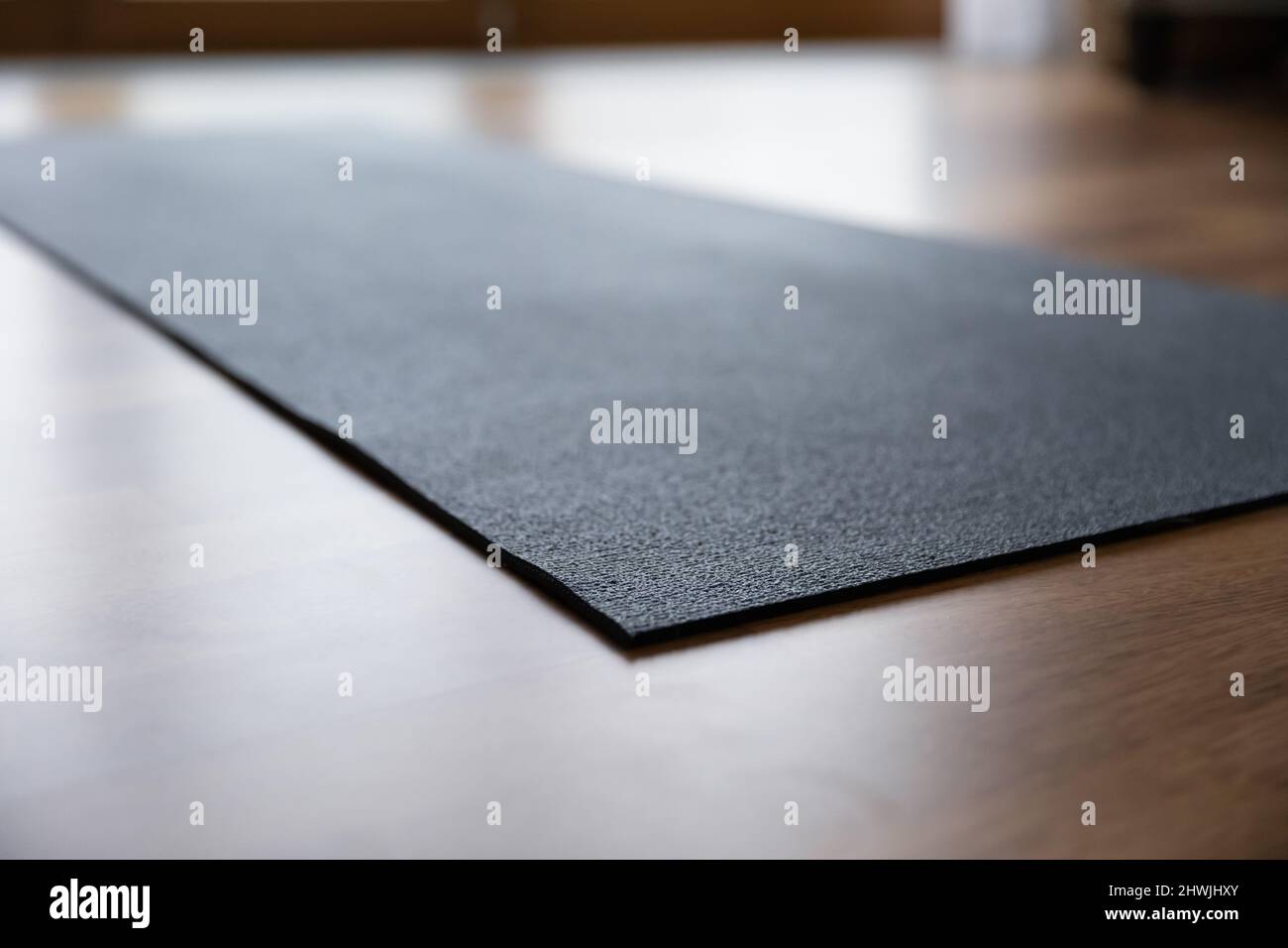 Empty black rubber yoga mat on floor, no people Stock Photo - Alamy