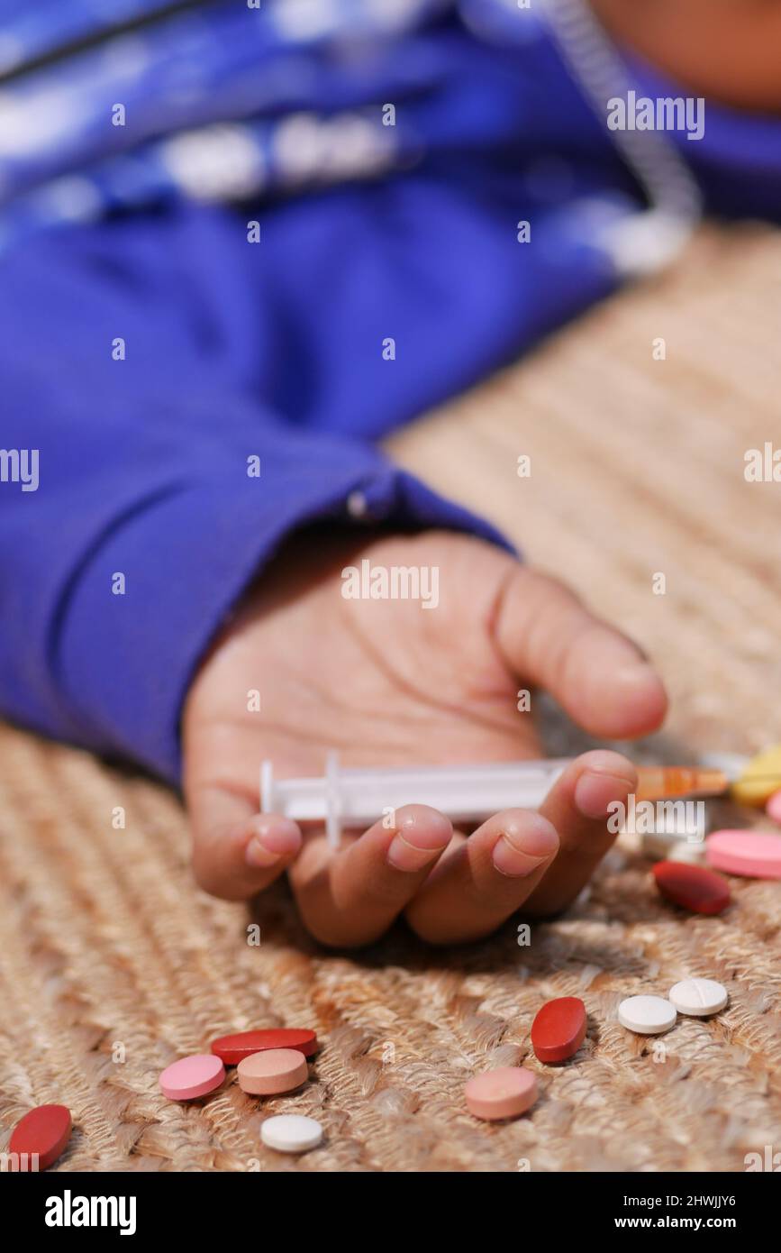 drug addiction concept with hand holding pills and syringe laying on ...