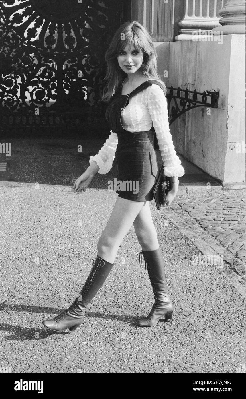 Model and horror film actress Madeline Smith poses wearing hot pants suit with knee high boots ...
