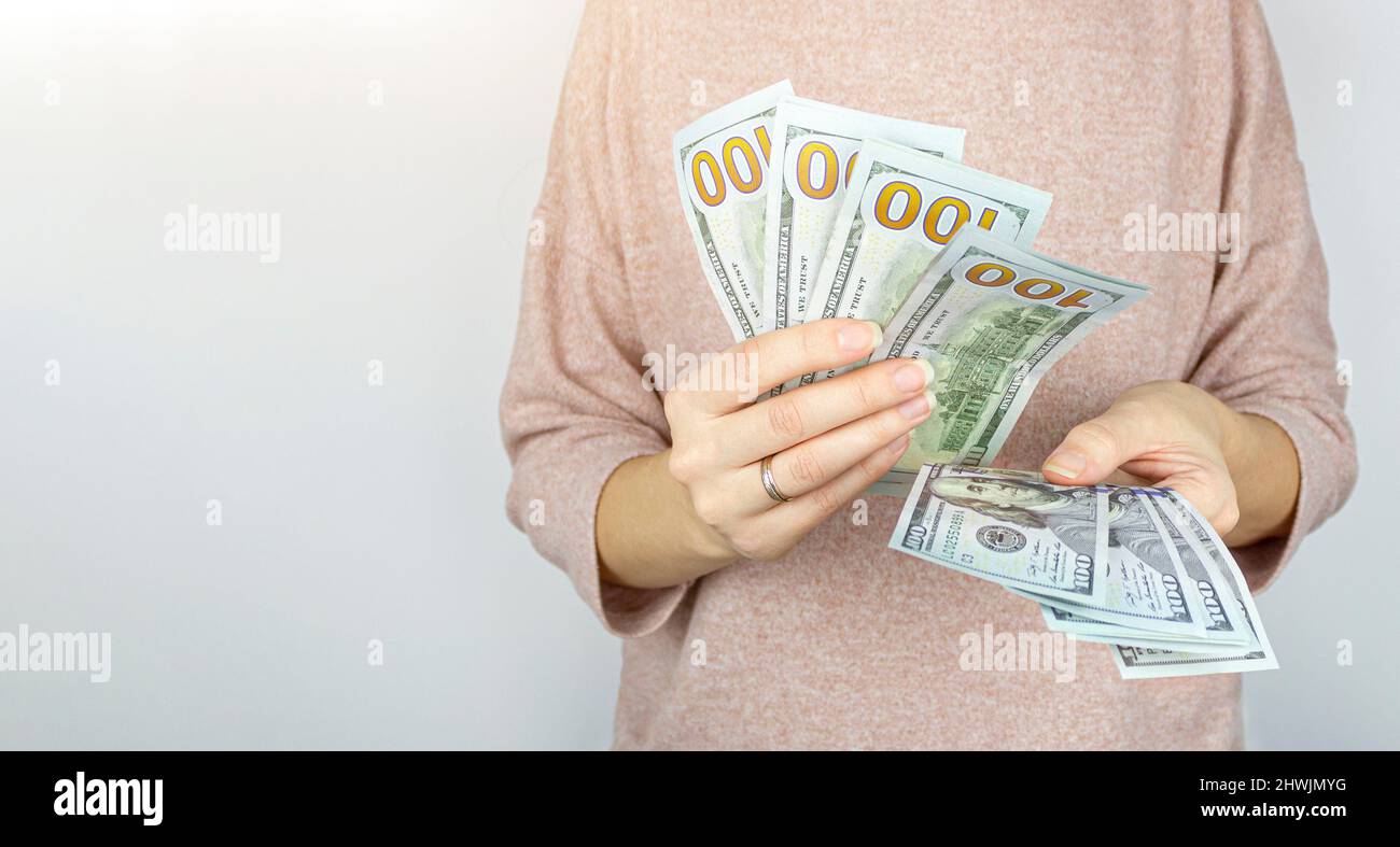 Woman counting dollar bills on greybackground. Counting or spend money ...
