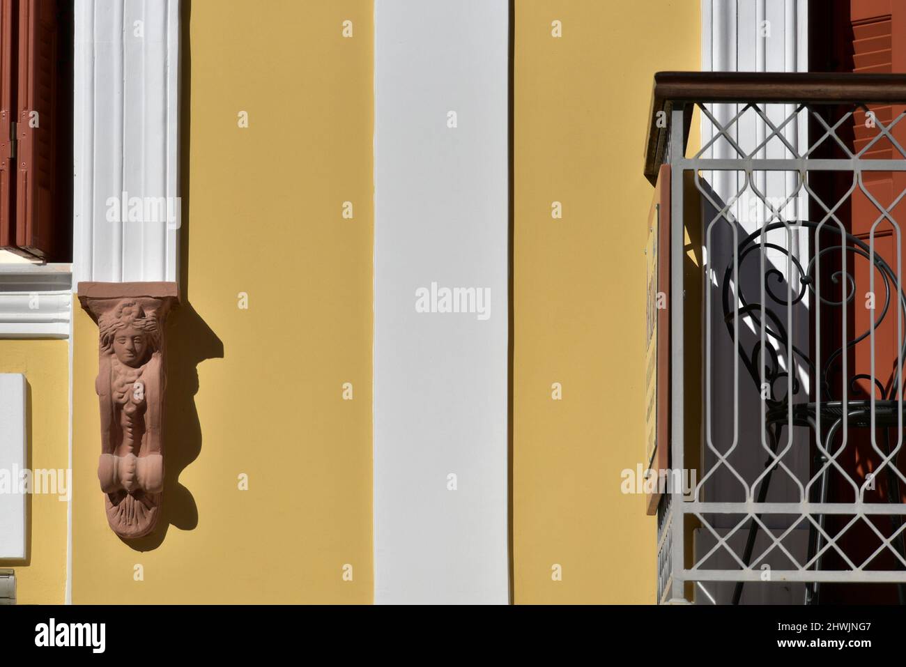 Old Neoclassical house facade with an ochre stucco wall, white plaster ...
