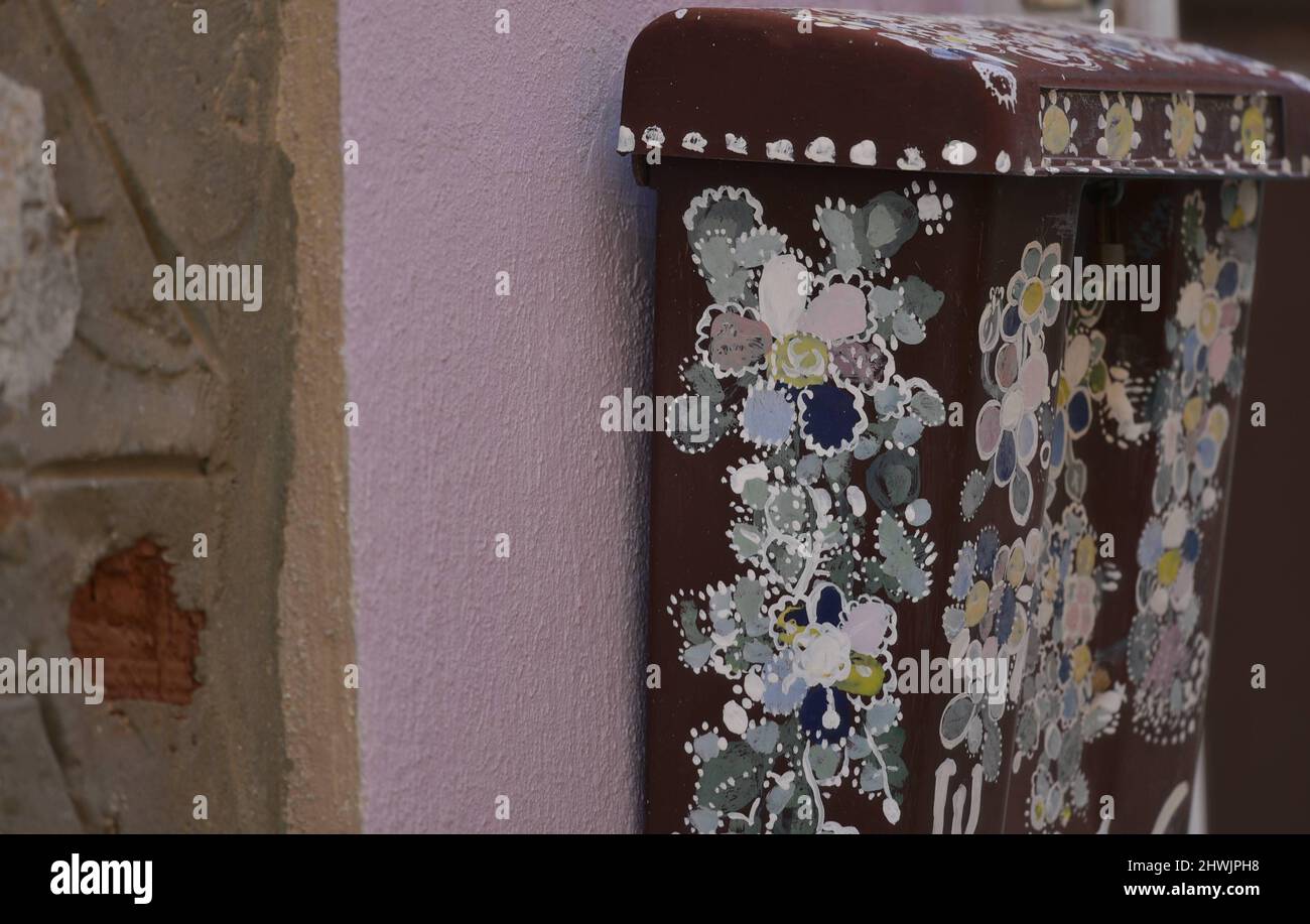 Traditional rural house hand painted metal mailbox against a pink ...