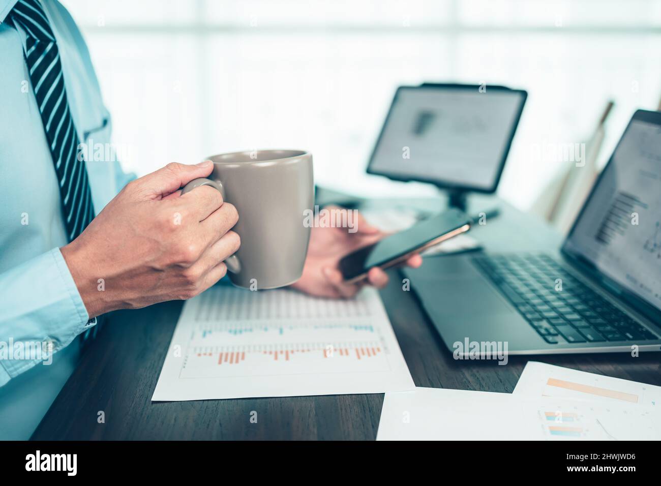 Businessman drink coffee and use cell phone and working on office desk ...