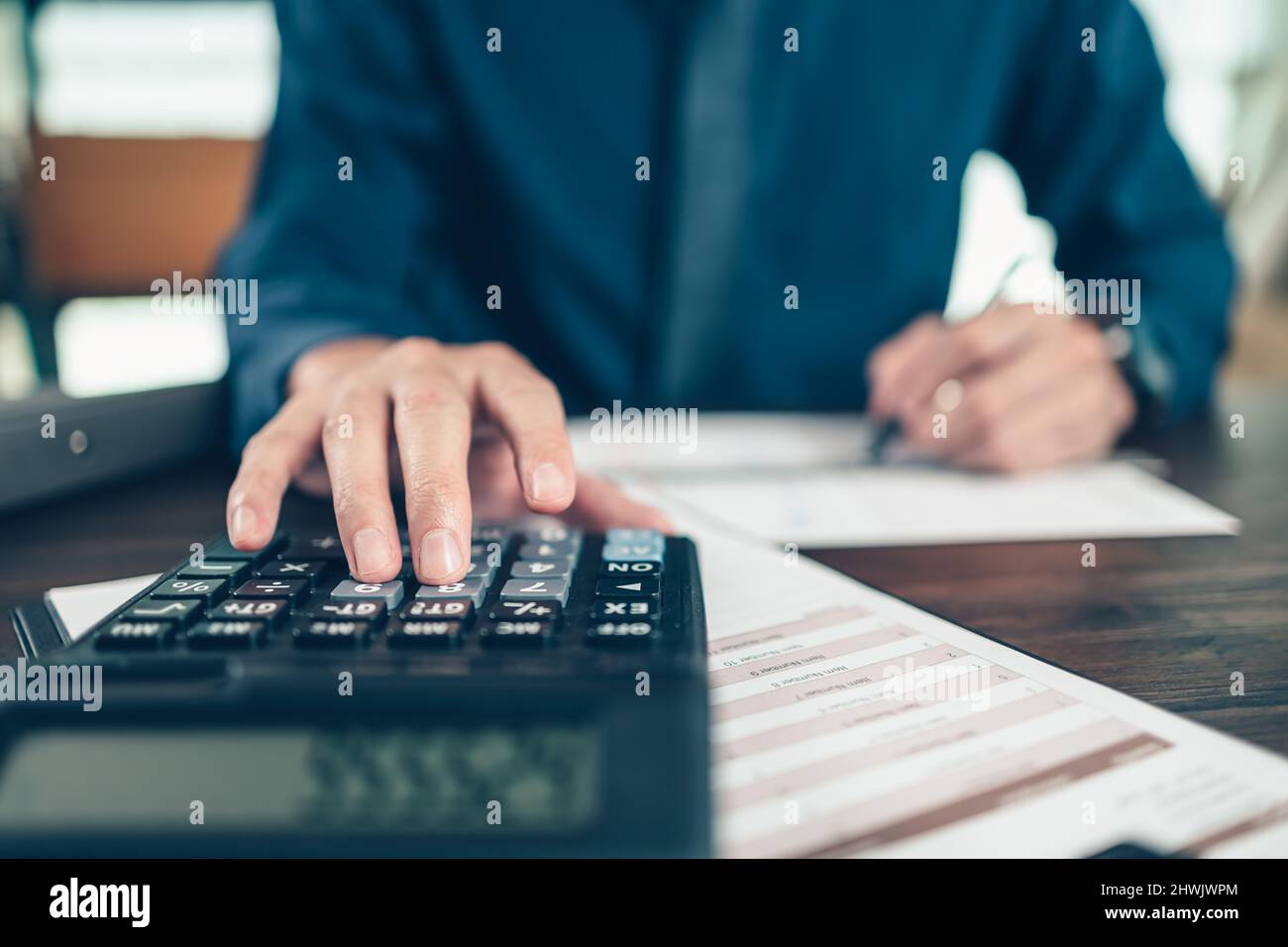 Financial businessman working on desk office using a calculator to ...