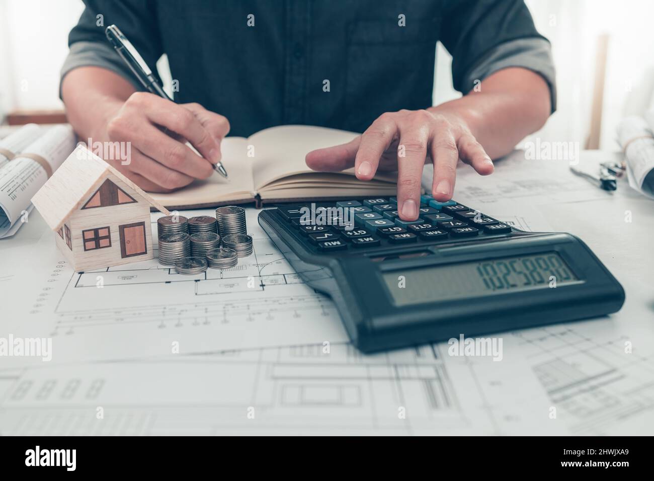 Architect engineer use calculator check cost house design on bueprint ...