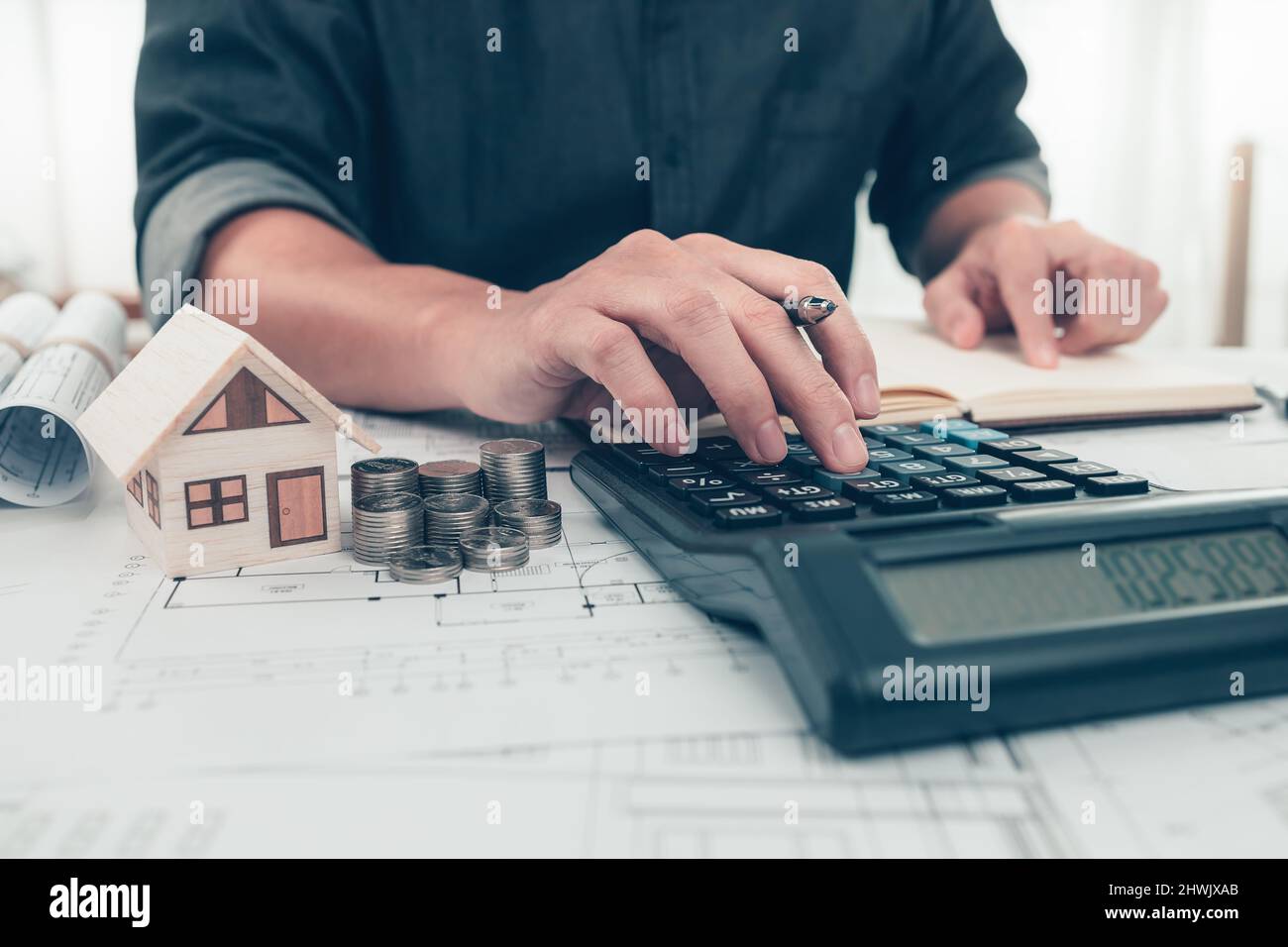 Architect engineer use calculator check cost house design on bueprint ...