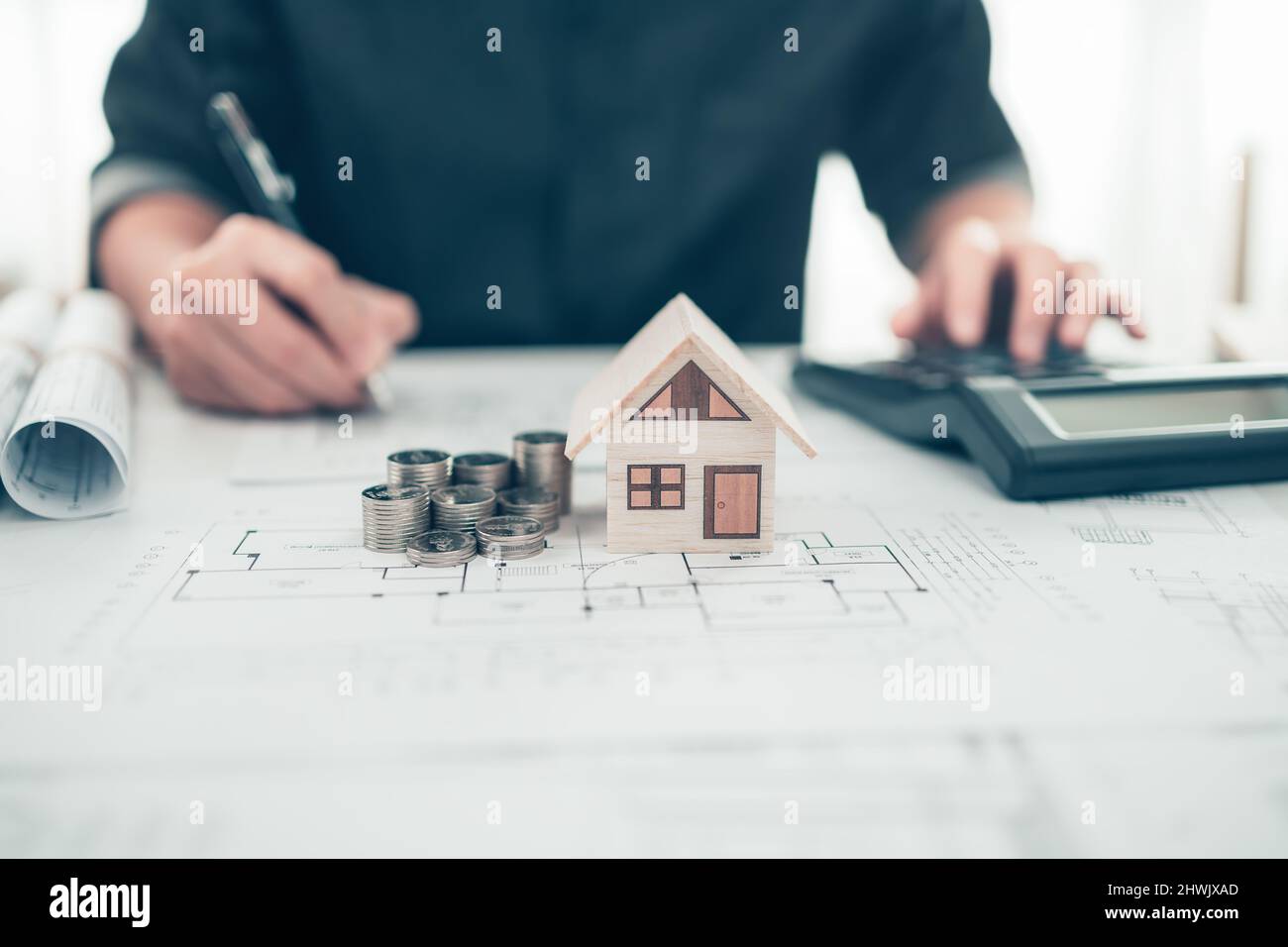 Mini model house and money coin on blueprint house plan design. Cost ...