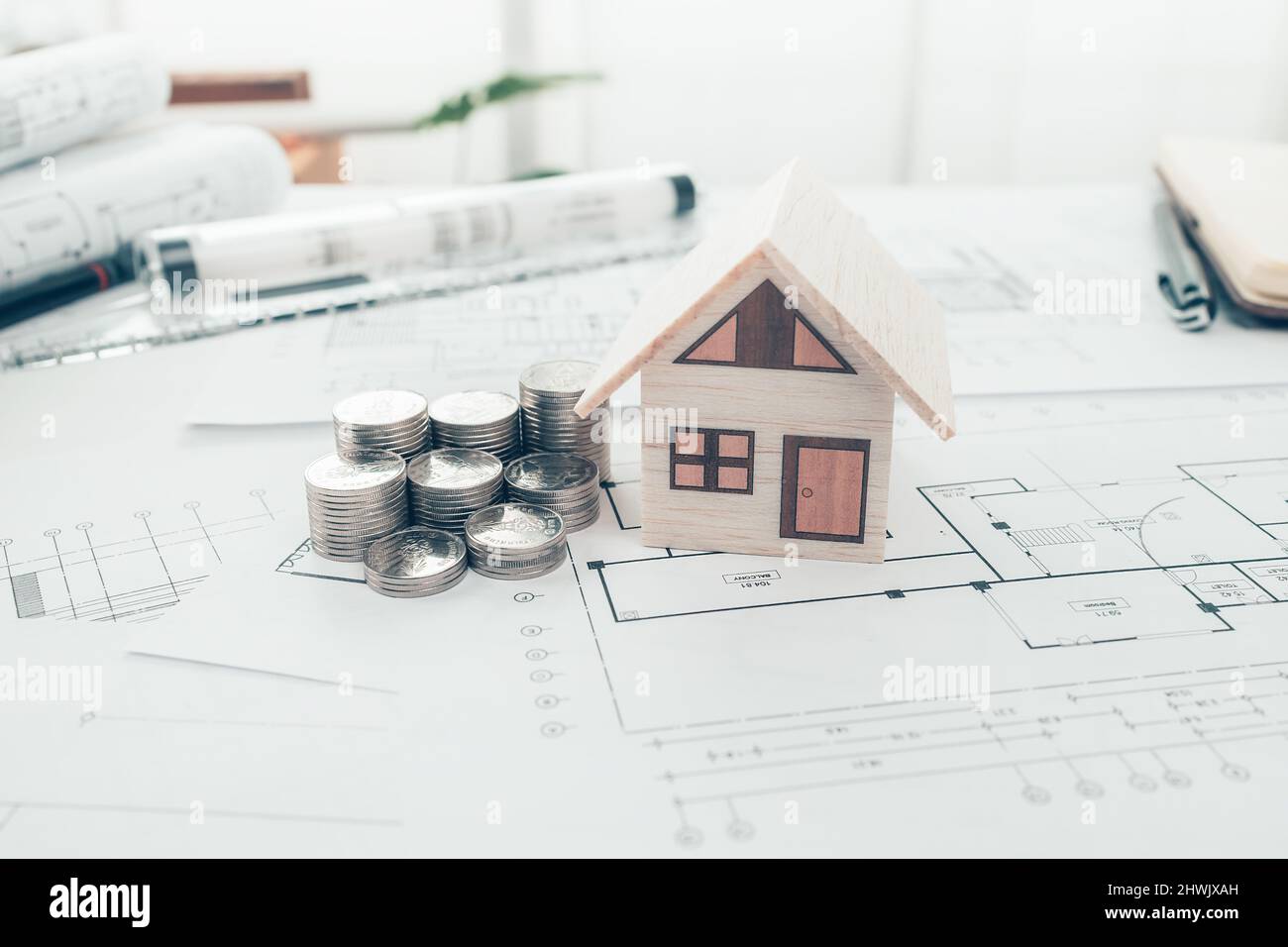Mini model house and money coin on blueprint house plan design. Cost ...