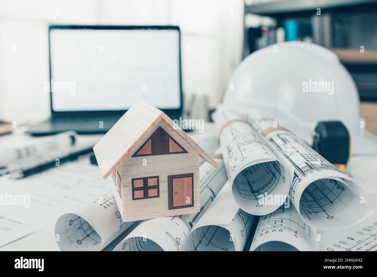 Mini model house, pencil, protractor, tape measure, compass, laptop and ...