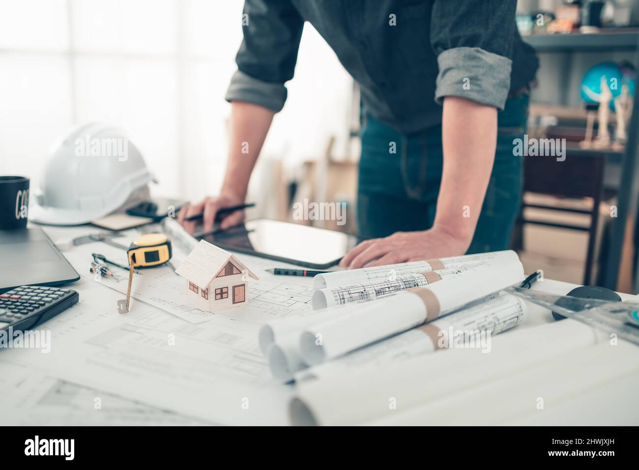 Mini model house on blueprint plan while architector standing and ...