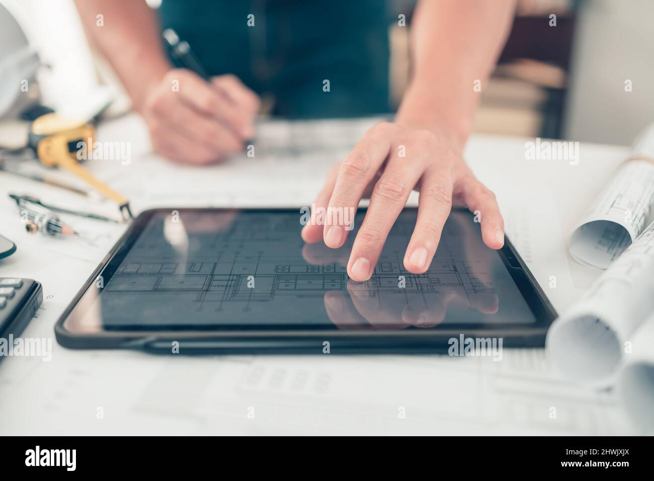 Architect engineer use tablet read and check drawing design working on ...