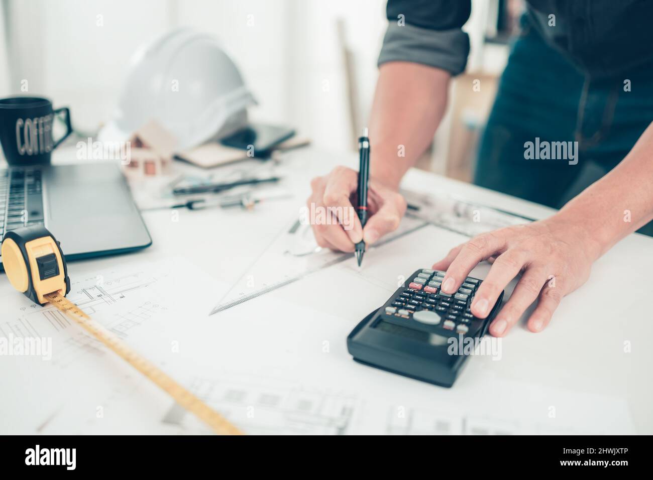 Architect engineer use calculator for calculate drawing design working on bueprint. House ...