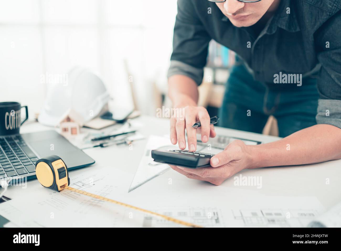 Architect engineer use calculator for calculate drawing design working ...