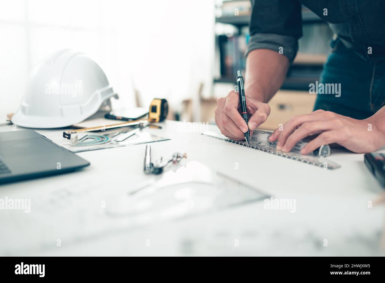 Architect engineer use pen and mini T-slide drawing design working on bueprint. House planning ...