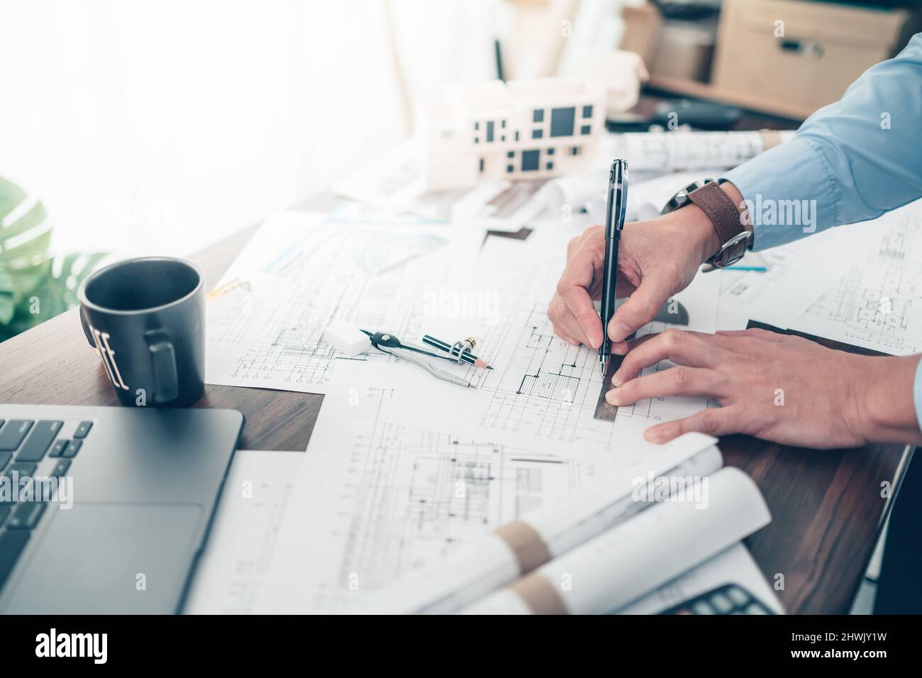 Architect engineer use pen and angle protector drawing design working on bueprint. House ...