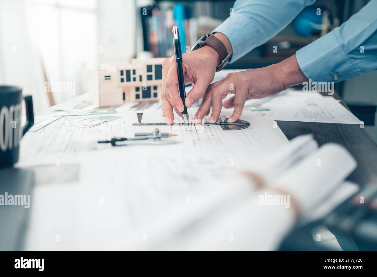 Architect engineer use pen and angle protector drawing design working on bueprint. House ...