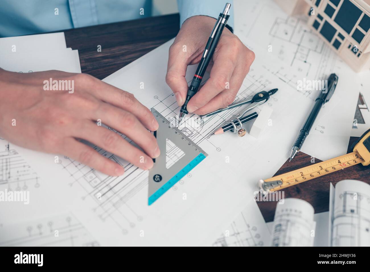 Architect engineer use pen and triangular angle ruler drawing design ...