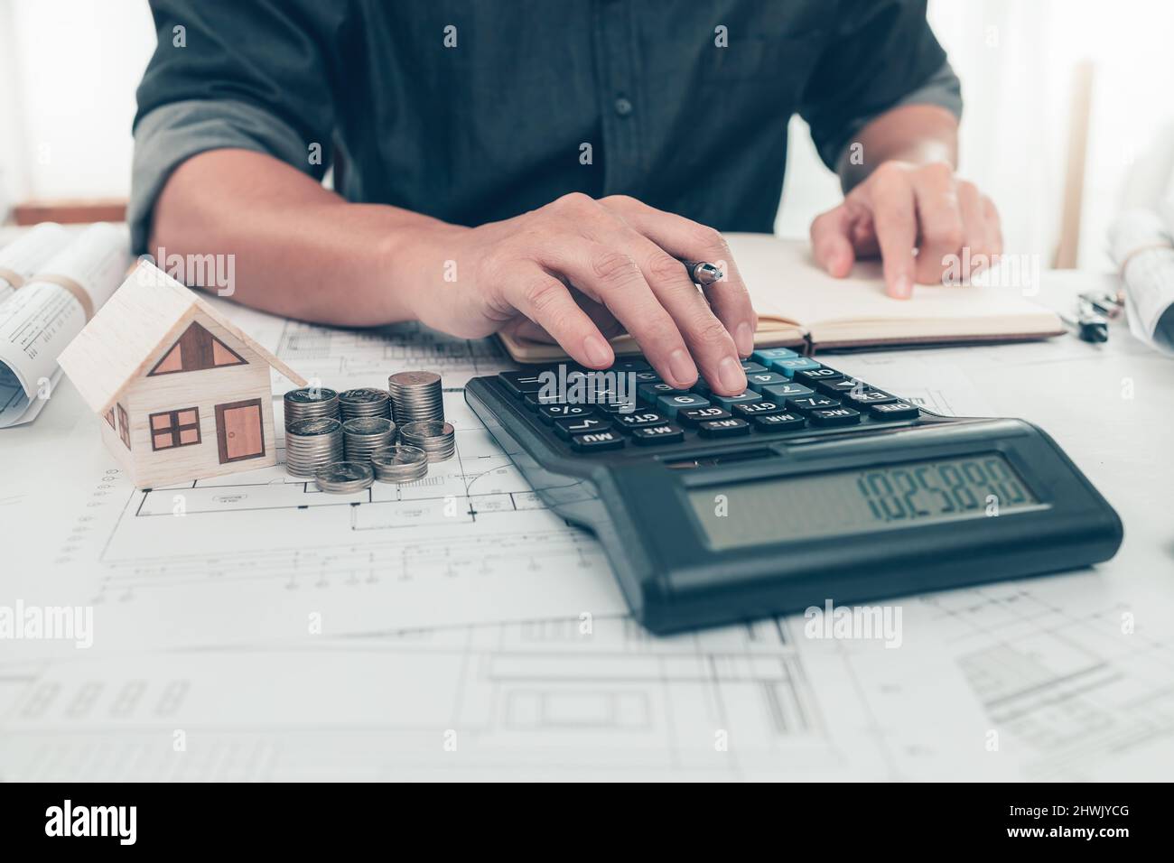 Architect engineer use calculator check cost house design on bueprint ...