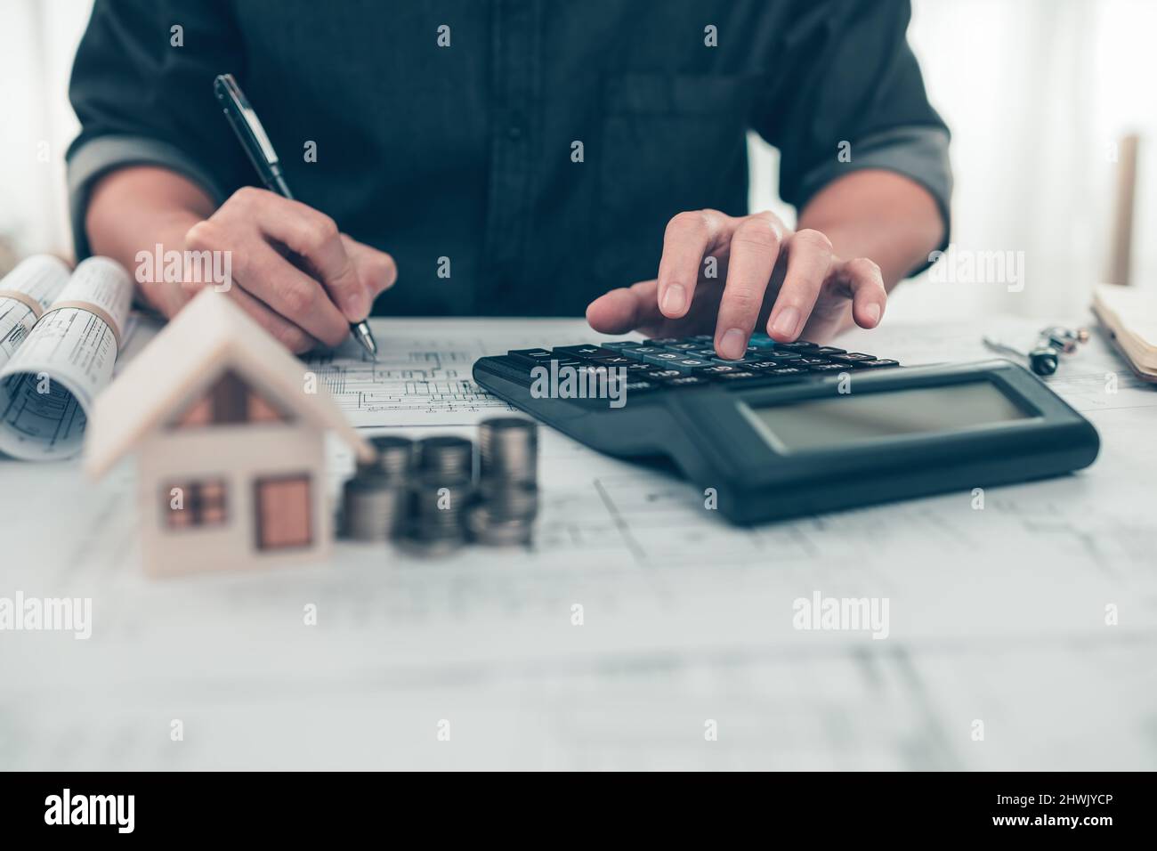Architect engineer use calculator check cost house design on bueprint ...