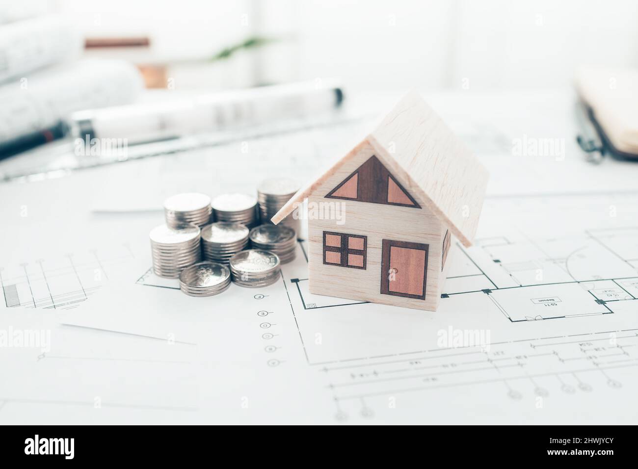 Mini model house and money coin on blueprint house plan design. Cost ...